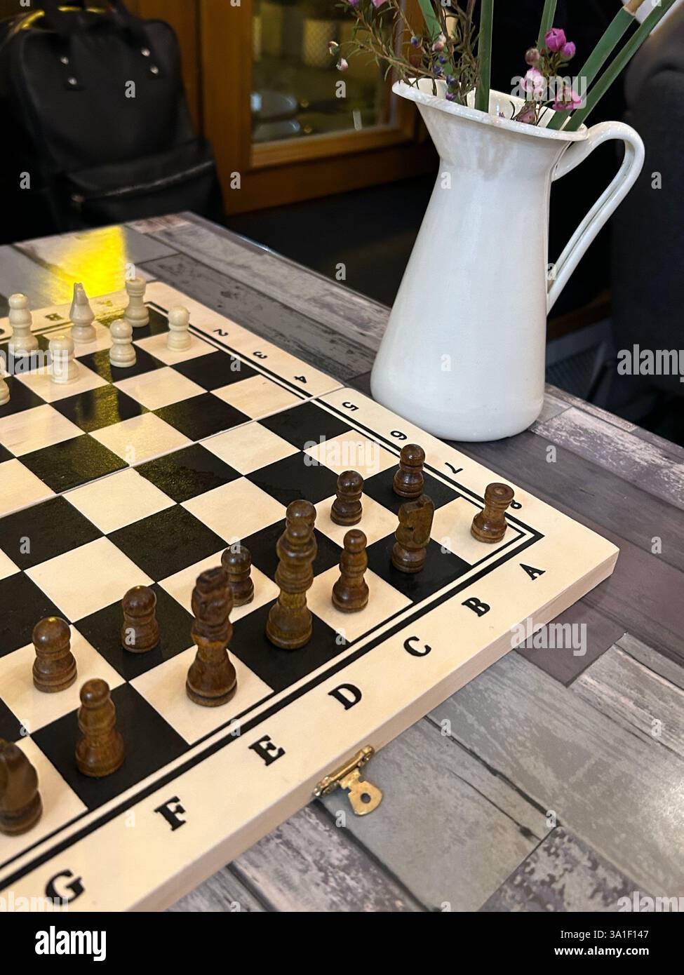 A wooden chess board on the table at the restaurant, playing brain game ...