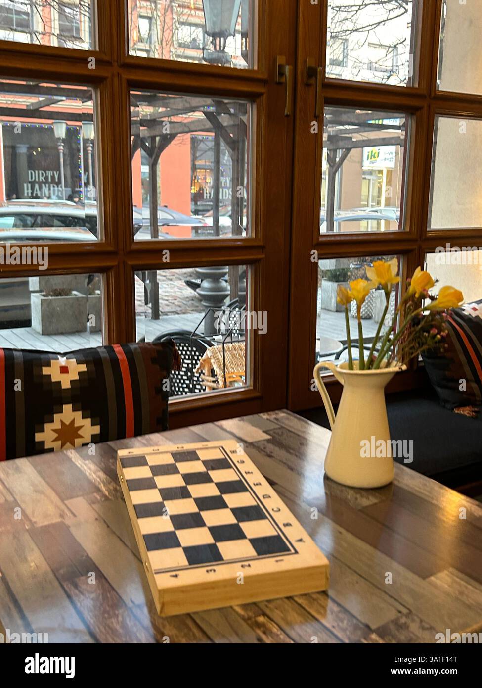 A wooden chess board on the table at the restaurant, playing brain game ...