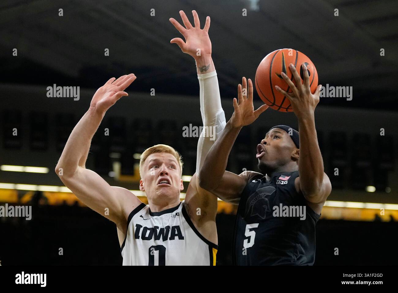 Michigan State guard Tre Holloman (5) drives to the basket past Iowa ...