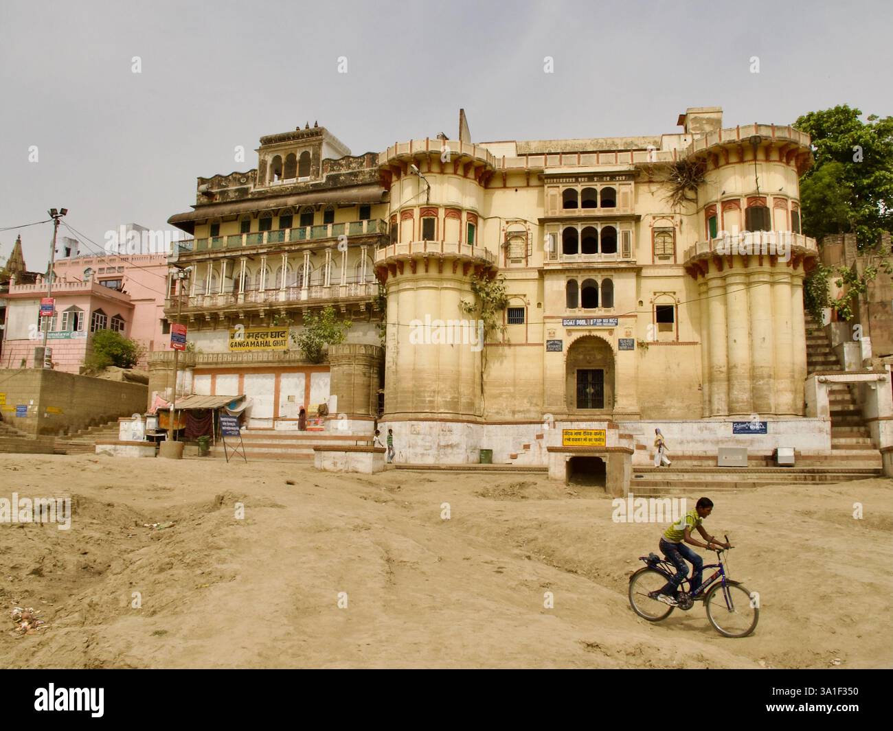 Riwa Ghat in Varanasi with ornate riverside architecture and a boy ...