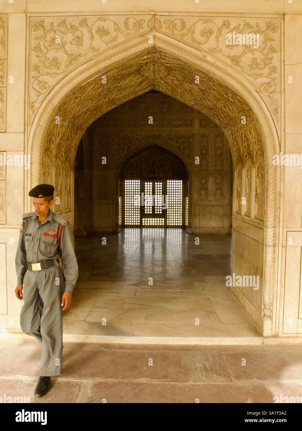 Indian security guard near the intricately carved marble archways of ...