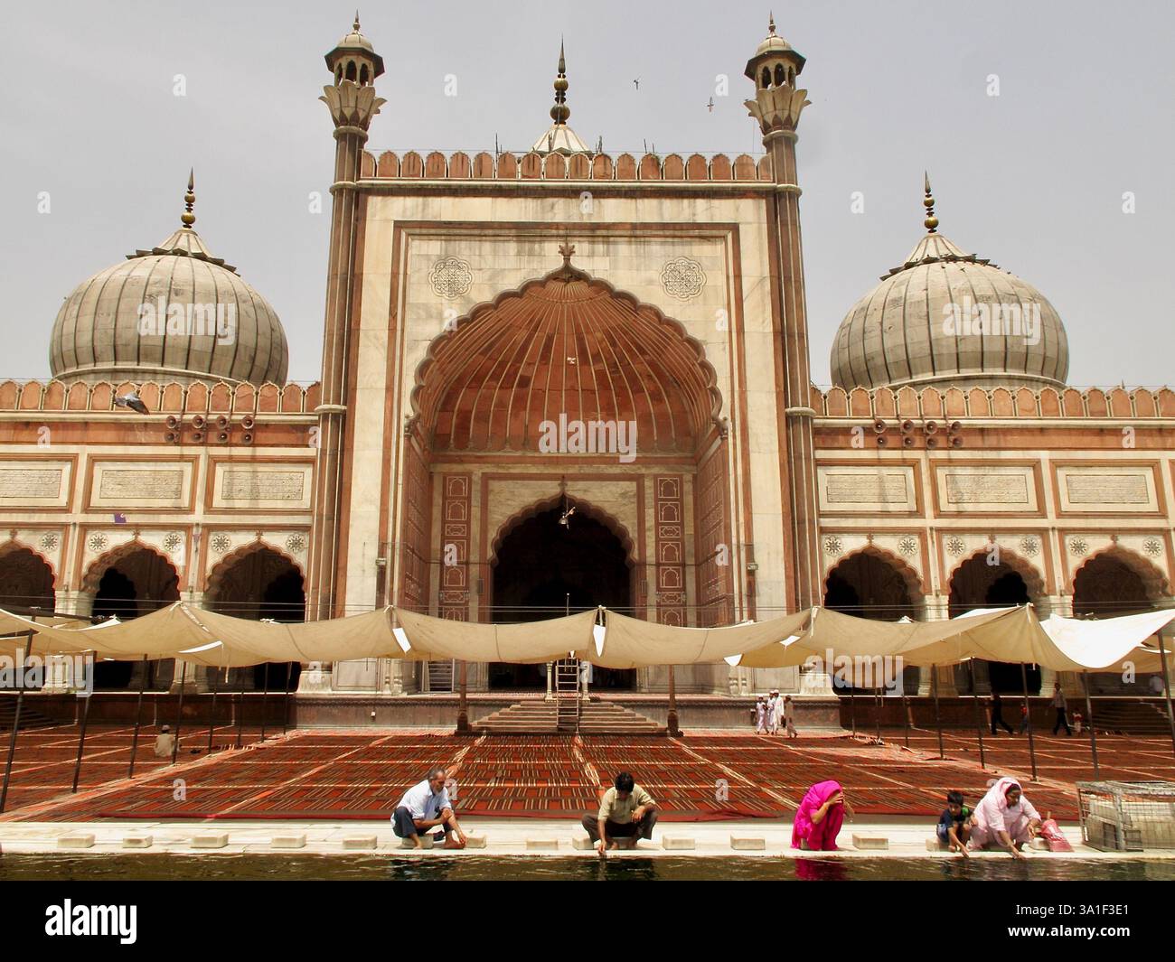 People wash at the central ablution tank of Jama Masjid, New Delhi ...