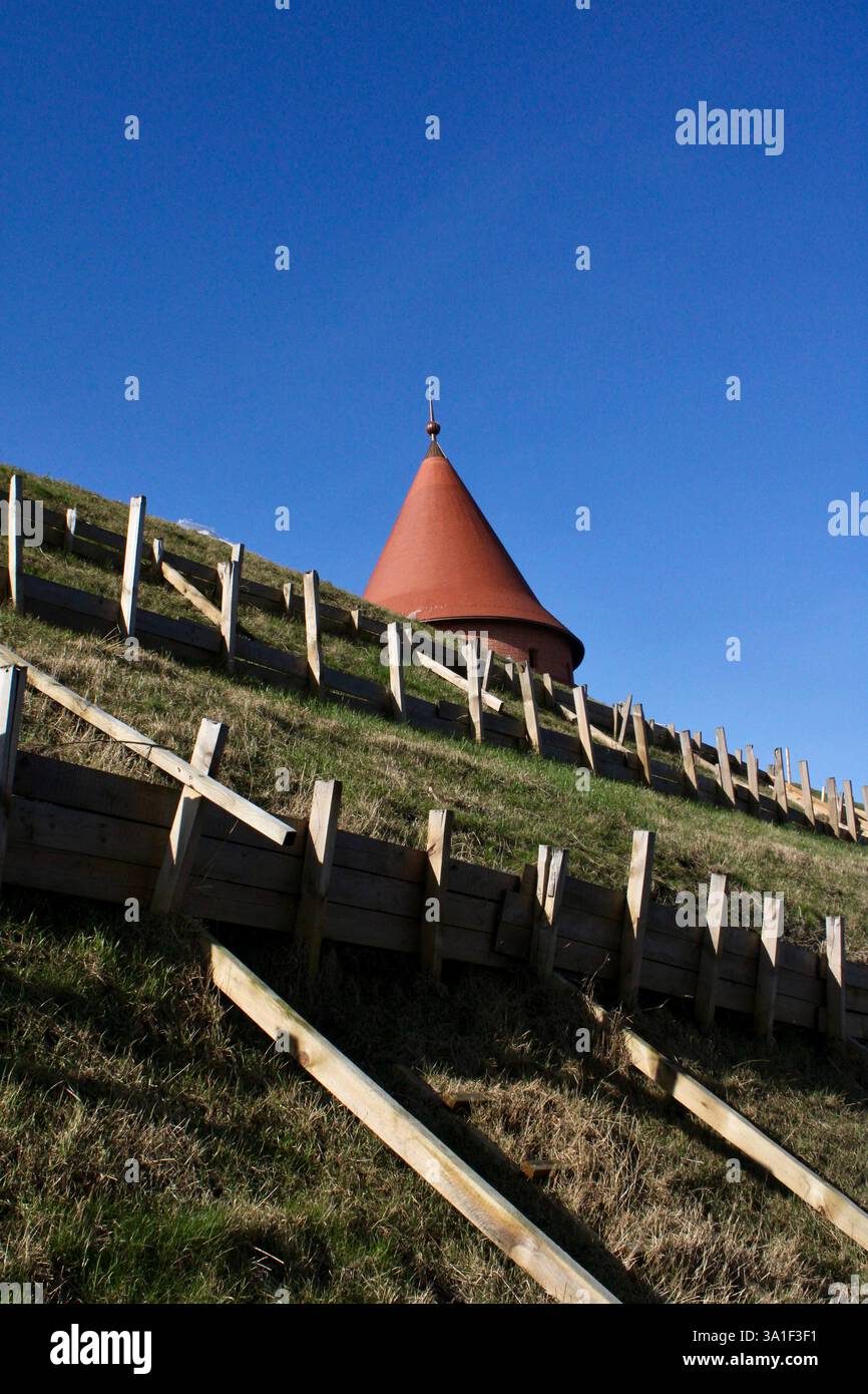 Red brick old tower in the European town buder the clear blue sky in ...