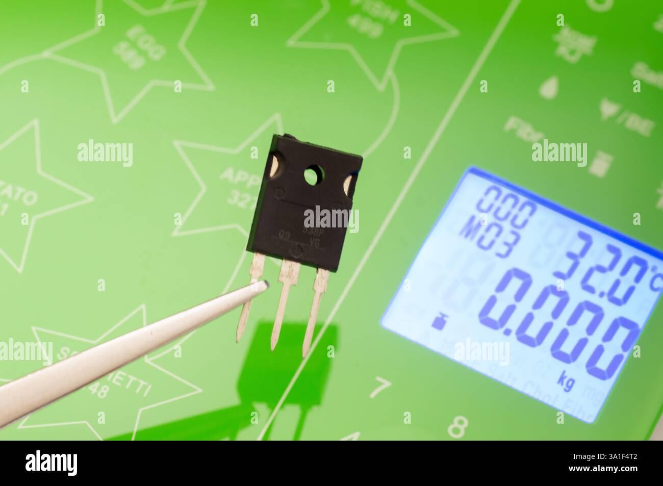 Weighing a transistor on a scale Stock Photo - Alamy