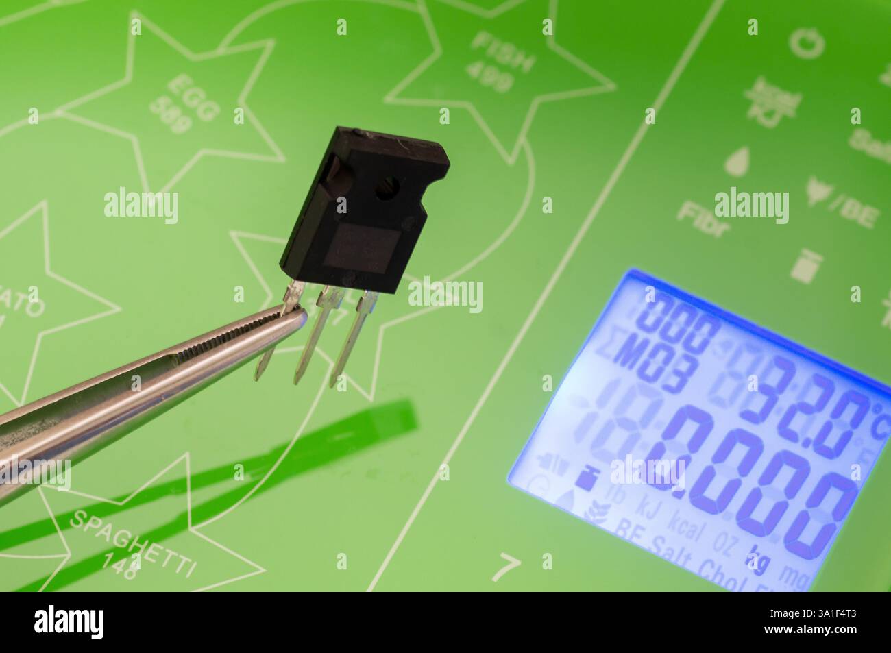 Weighing a transistor on a scale Stock Photo - Alamy