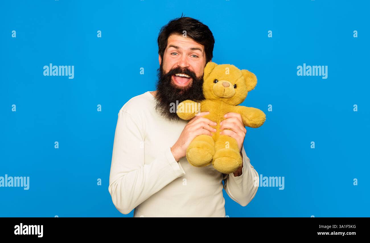 Teddy bear toy. Handsome male with beard holds soft teddy bear. Smiling ...