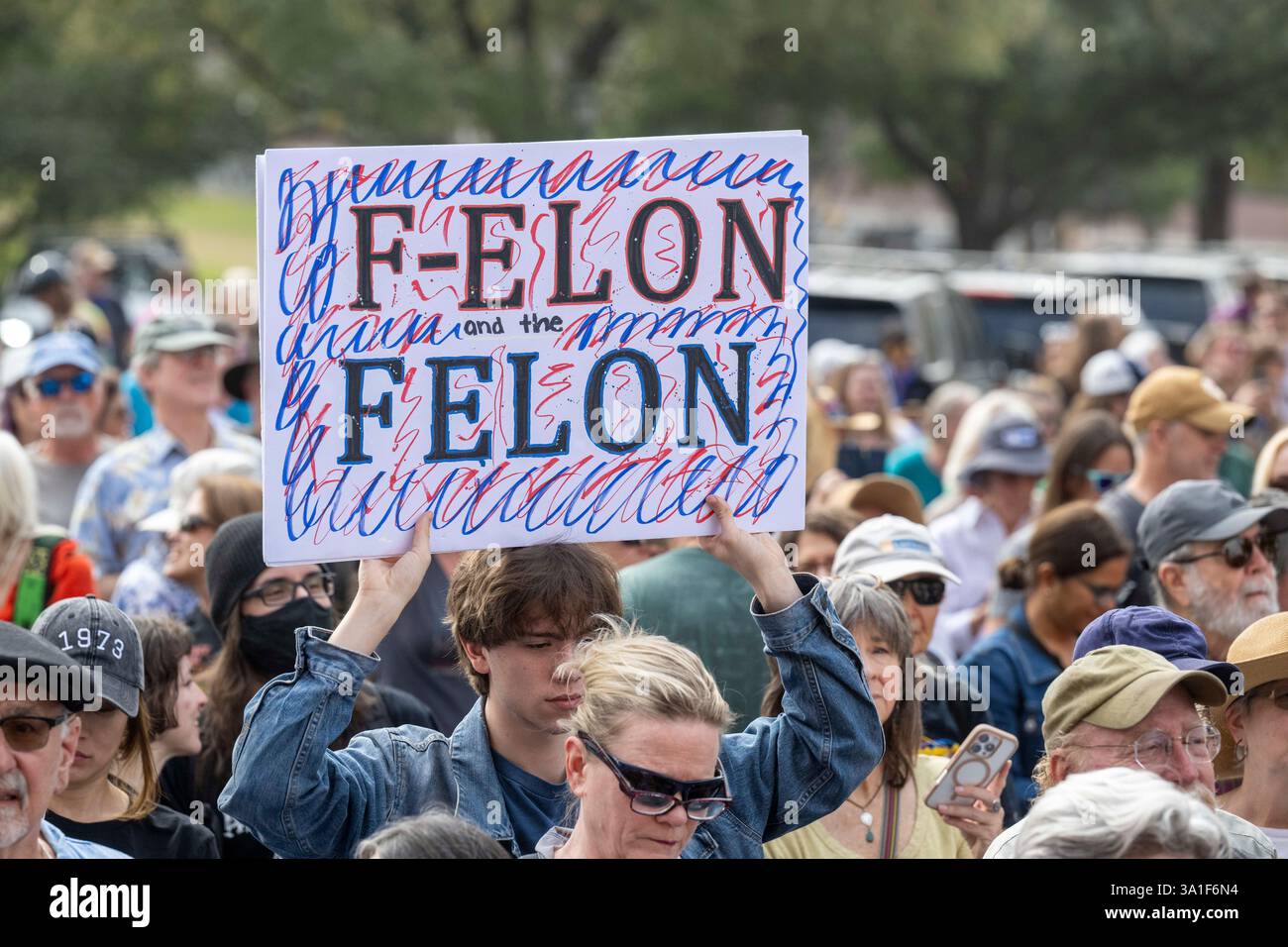 Protesters hold anti Donald Trump and anti-Elon Musk signs as about ...