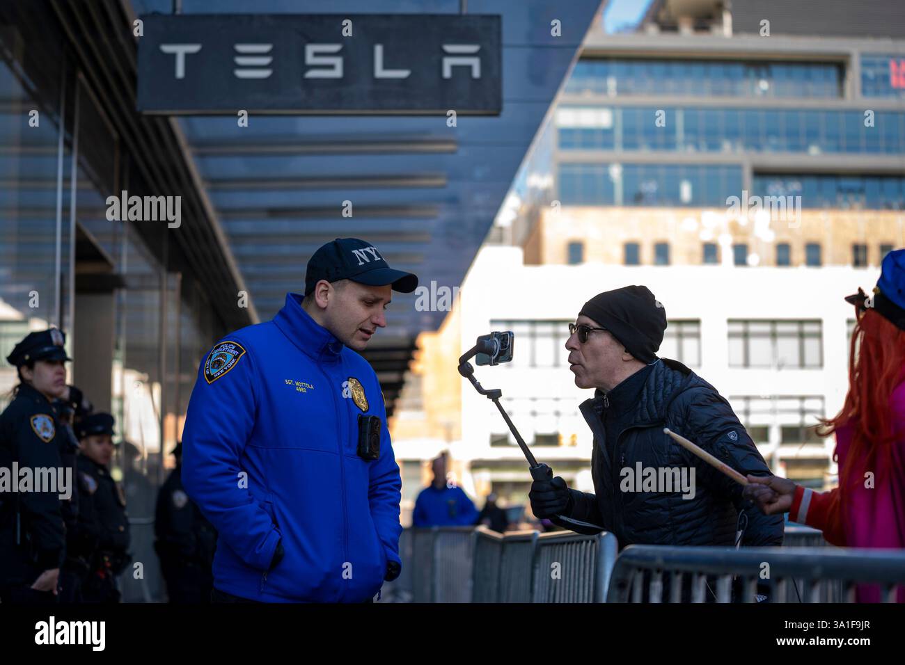 Protestors talk to the police guarding the Tesla New York storefront in ...