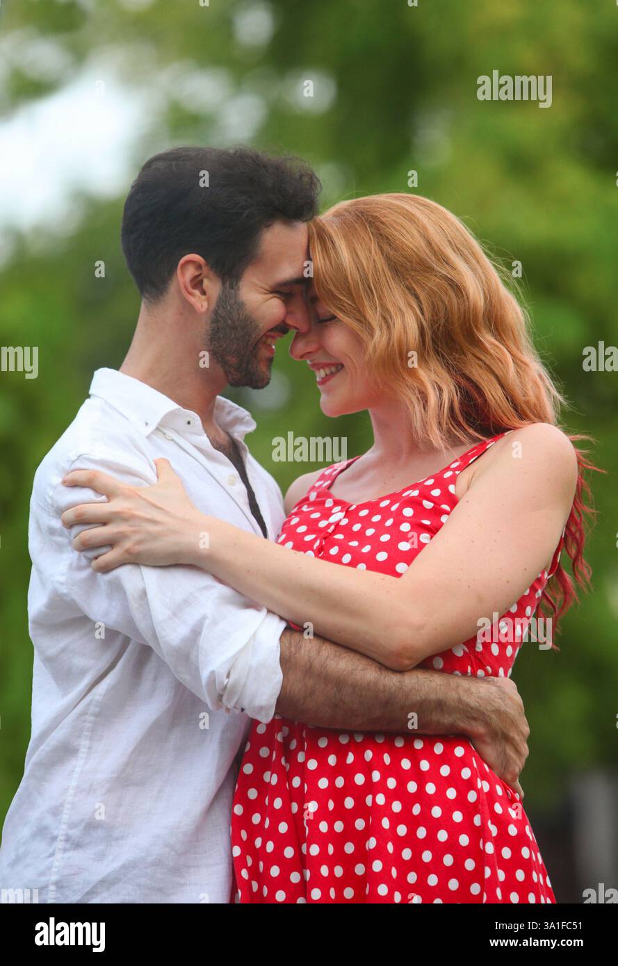 portrait of mid adult cheerful mixed-race couple in love in the park on ...