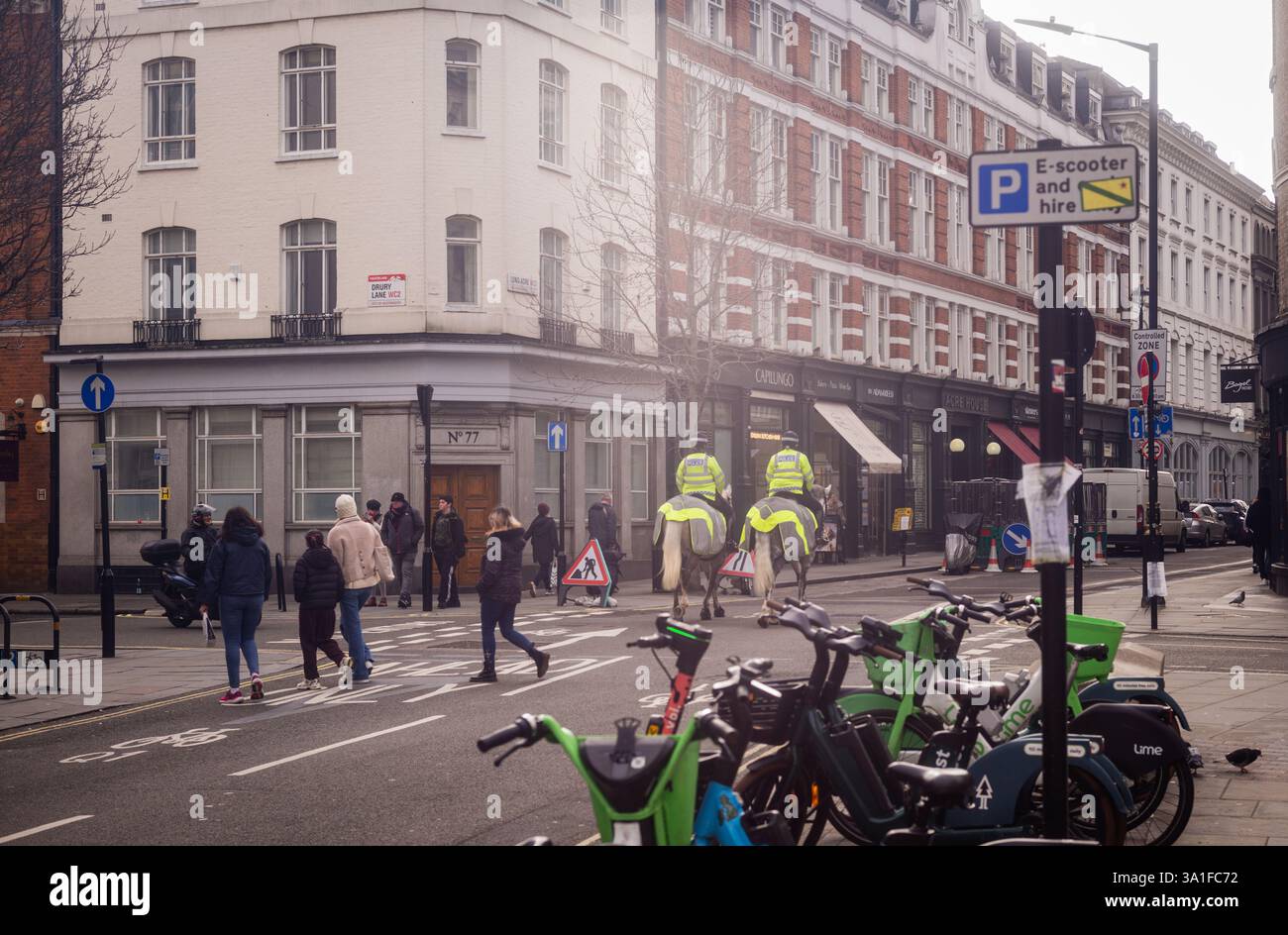 Metropolitan Police Officers riding on horses along Long Acre in the ...