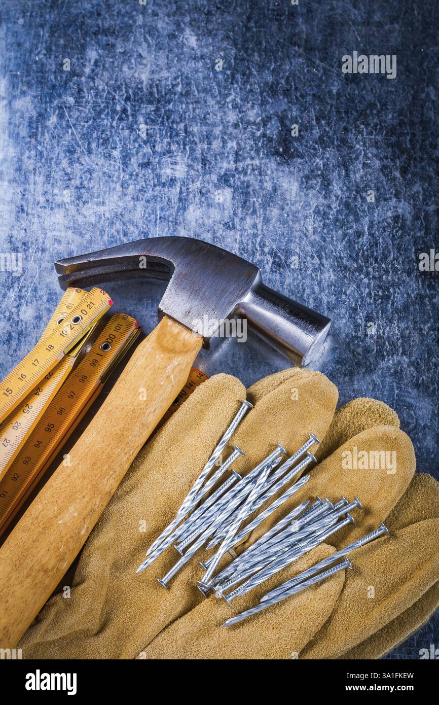 Leather safety working gloves set of construction nails wooden meter and claw hammer on ...