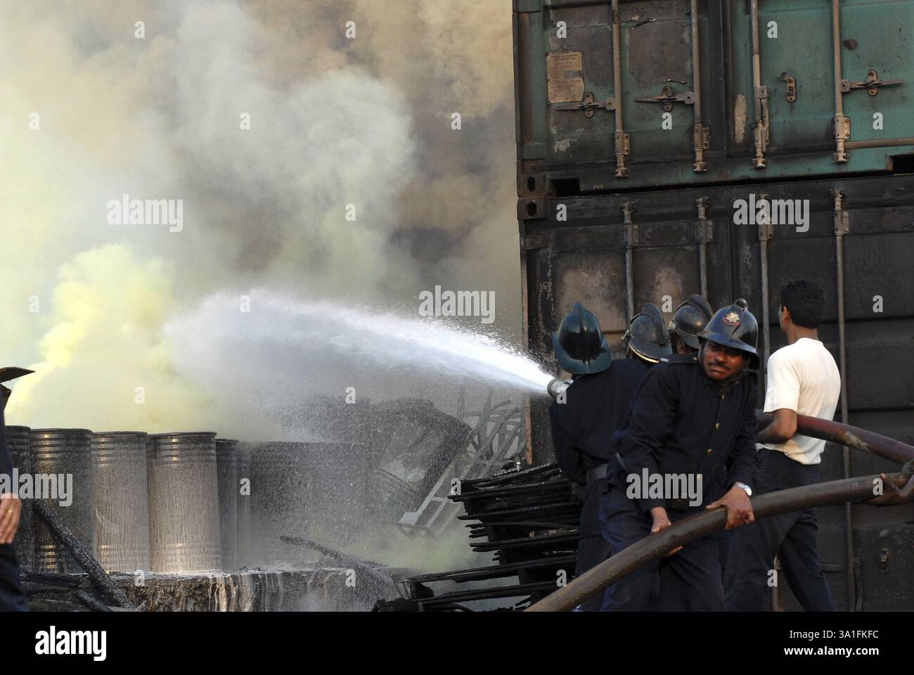 Fire brigade personnel or fire fighters trying to extinguish fire in ...