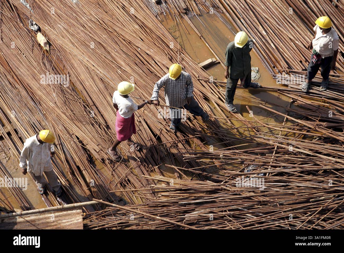 Workers straightening the iron rods needed to lay the foundation of ...