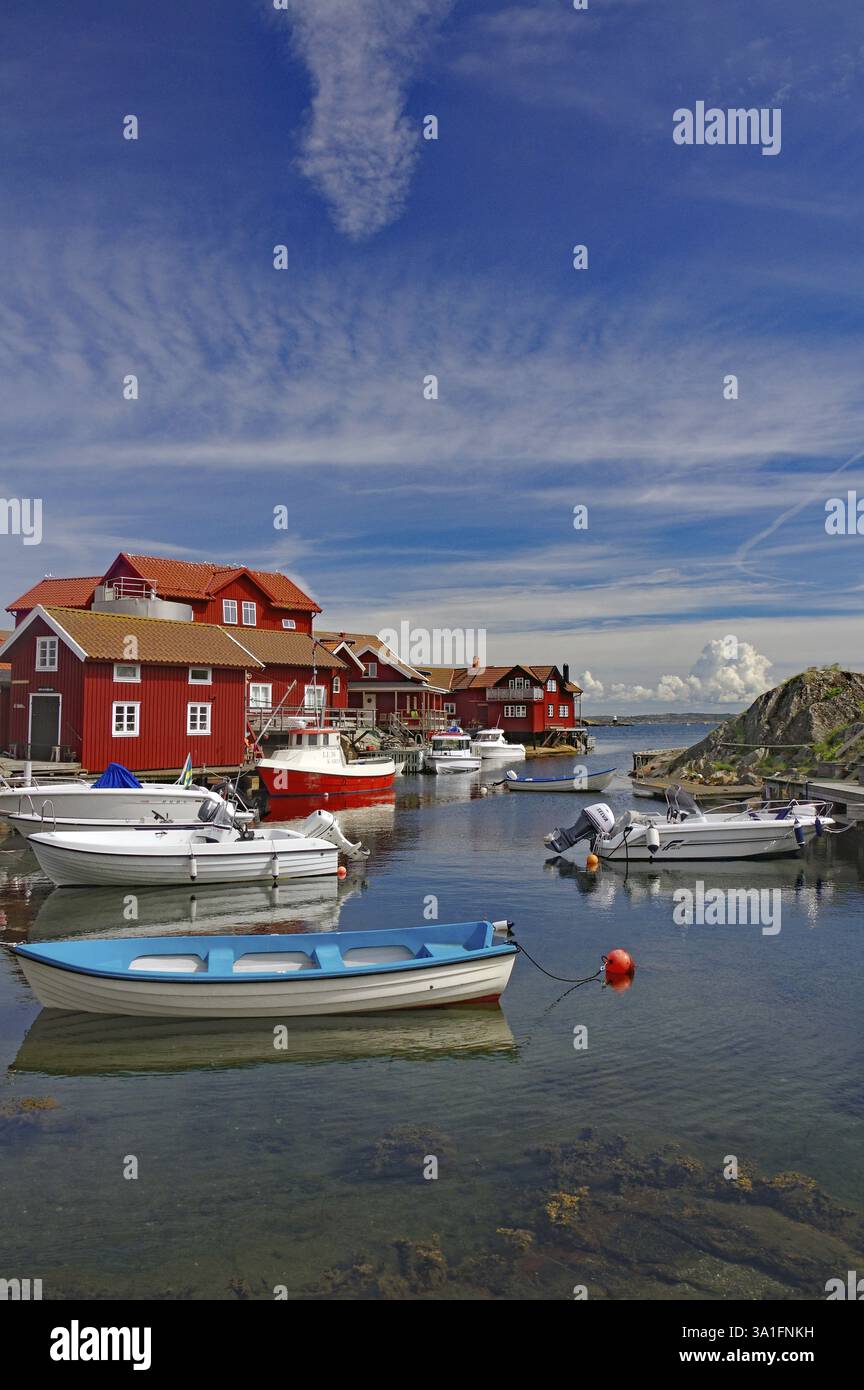 Red wooden houses on the shore, boats in the harbour, calm atmosphere ...