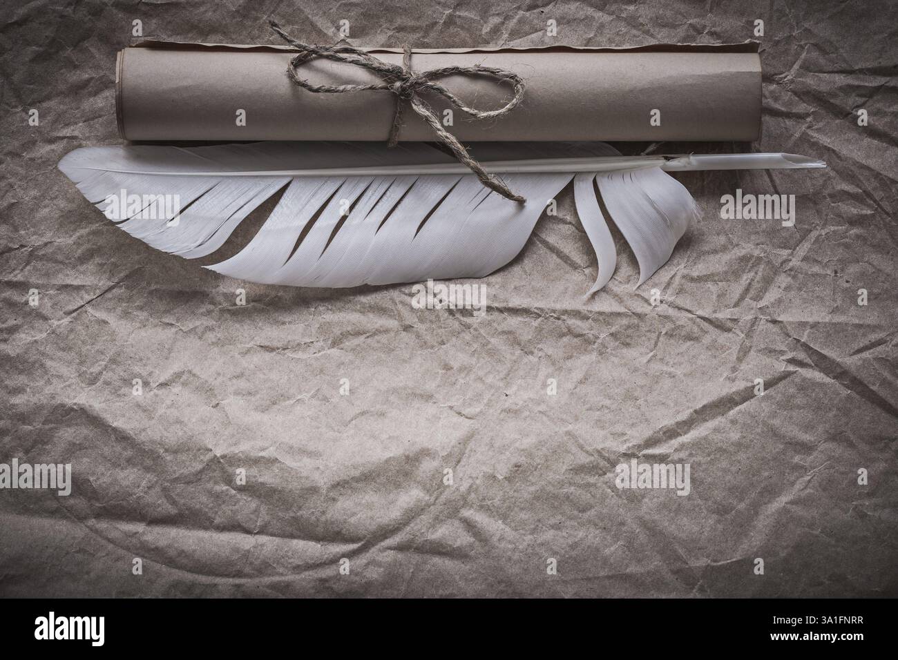 Medieval paper roll feather on crumpled wrapping sheet Stock Photo - Alamy