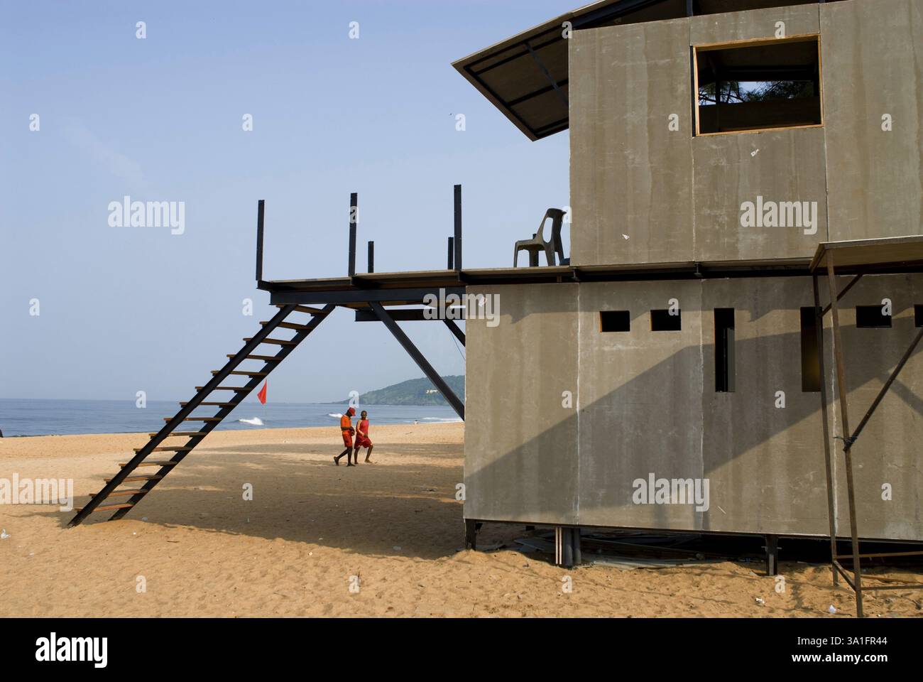 Coast guards wearing orange clothes walk past coast guard cabin ...