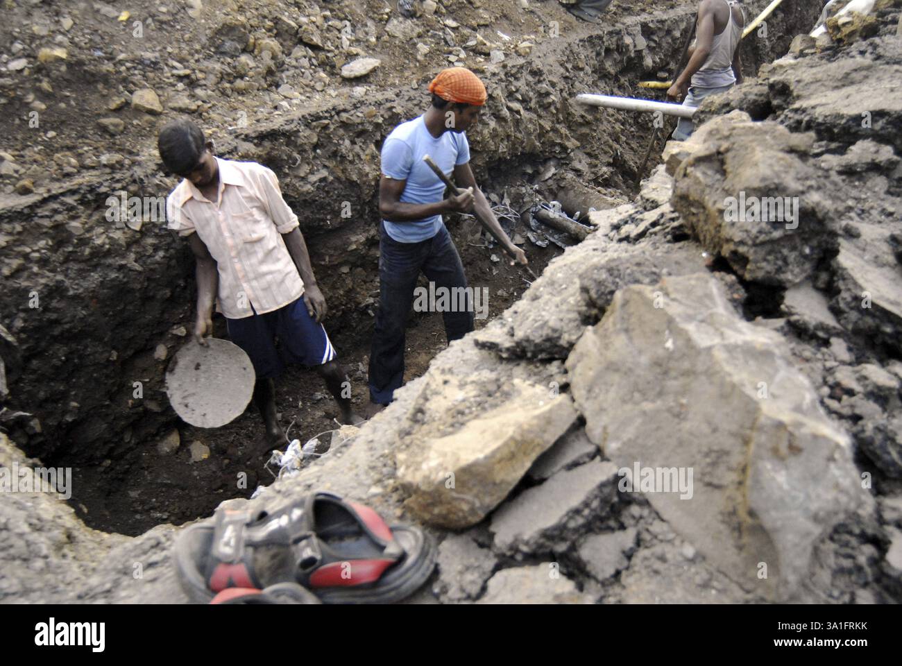 Road construction workers dig the road to lay an underground drainage ...
