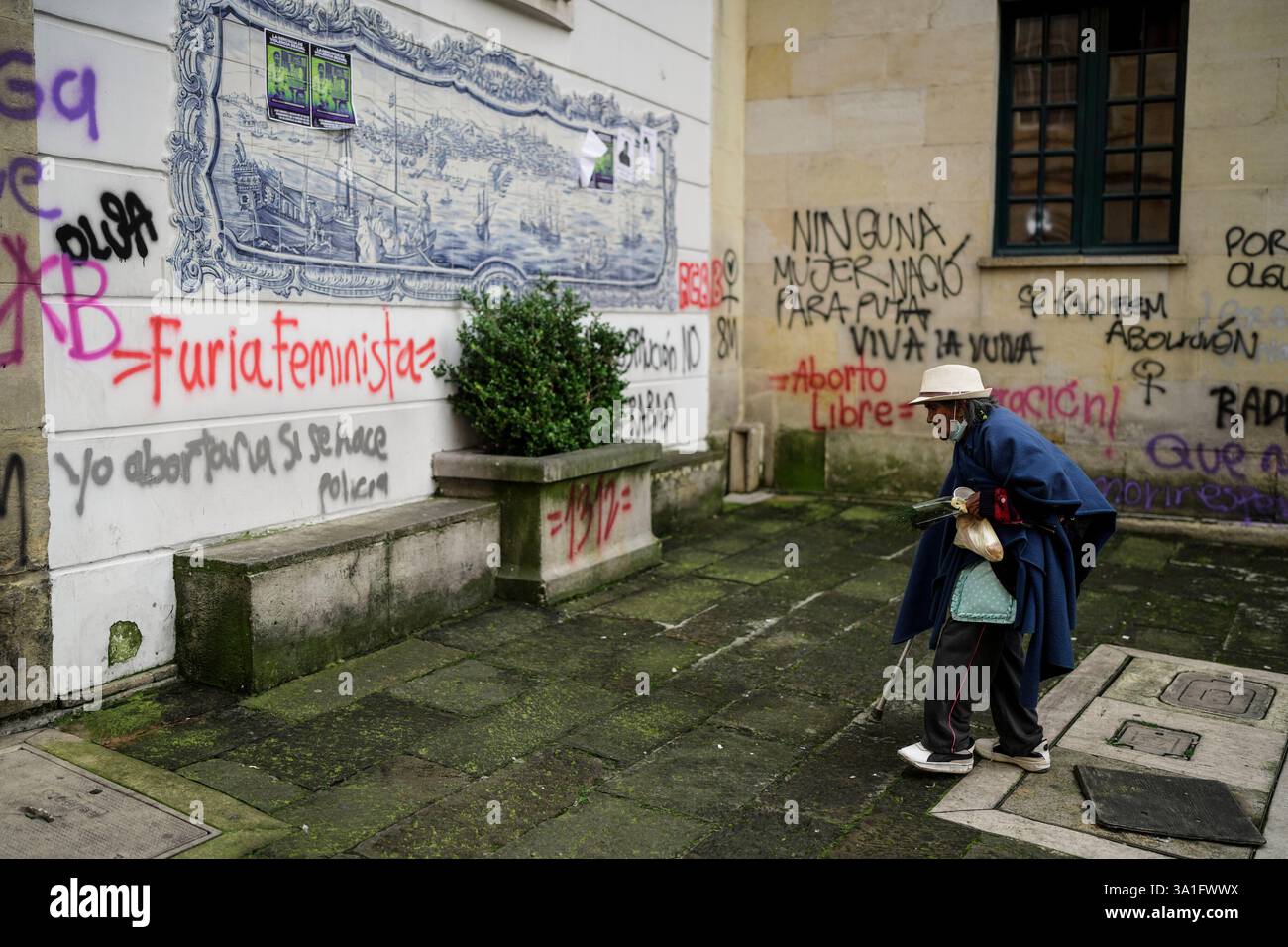 A woman views graffiti with slogans spray painted by participants of a ...