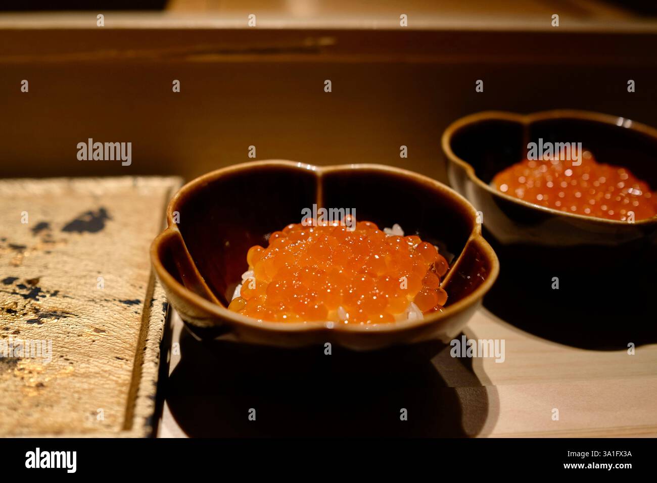 Two small glazed ceramic bowls of ikura don (salmon roe rice bowl ...