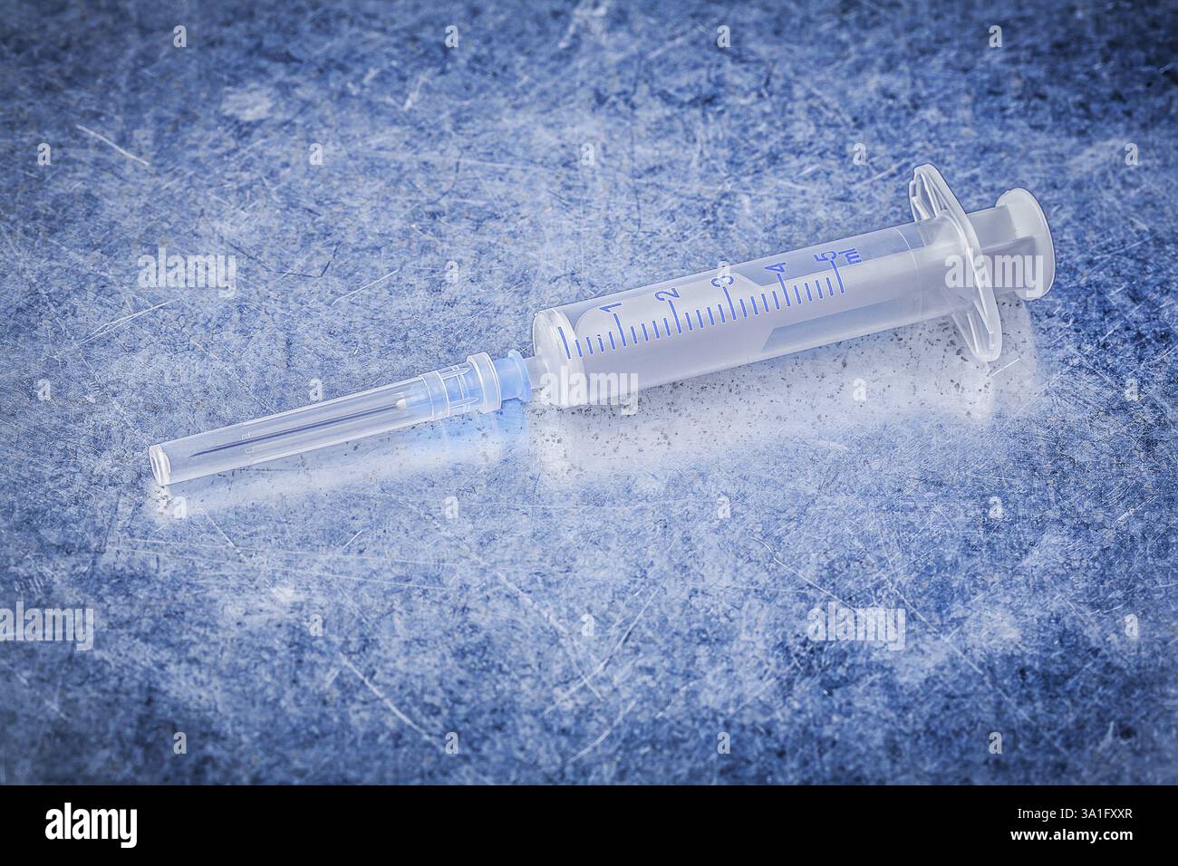 Medical disposable needle injector on scratched metallic background ...