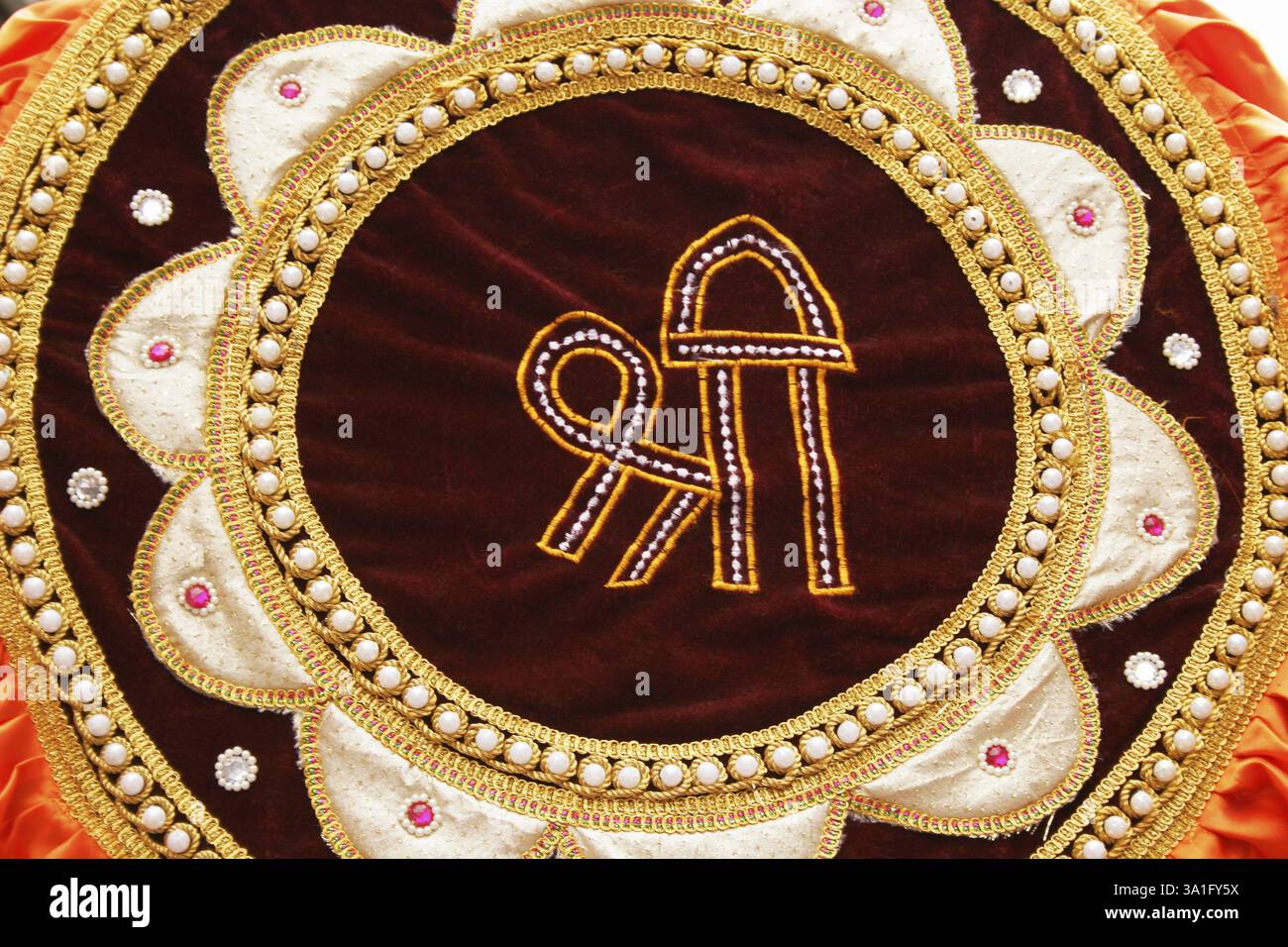 Maroon coloured velvet cloth decorated circular form of golden border ...