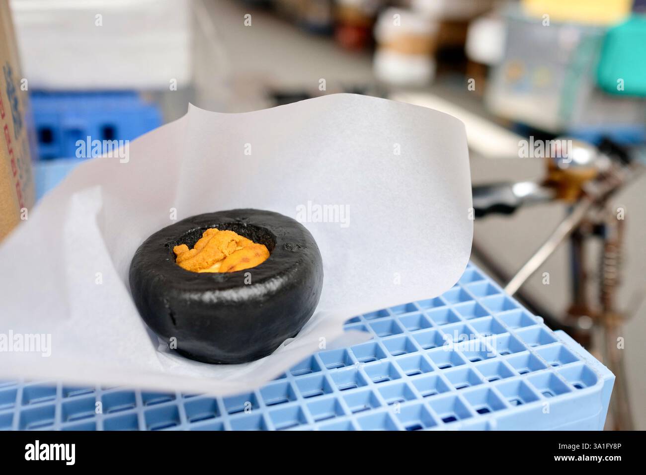 Steamed sea urchin bun from Hamada Shoten, on top of a blue plastic ...