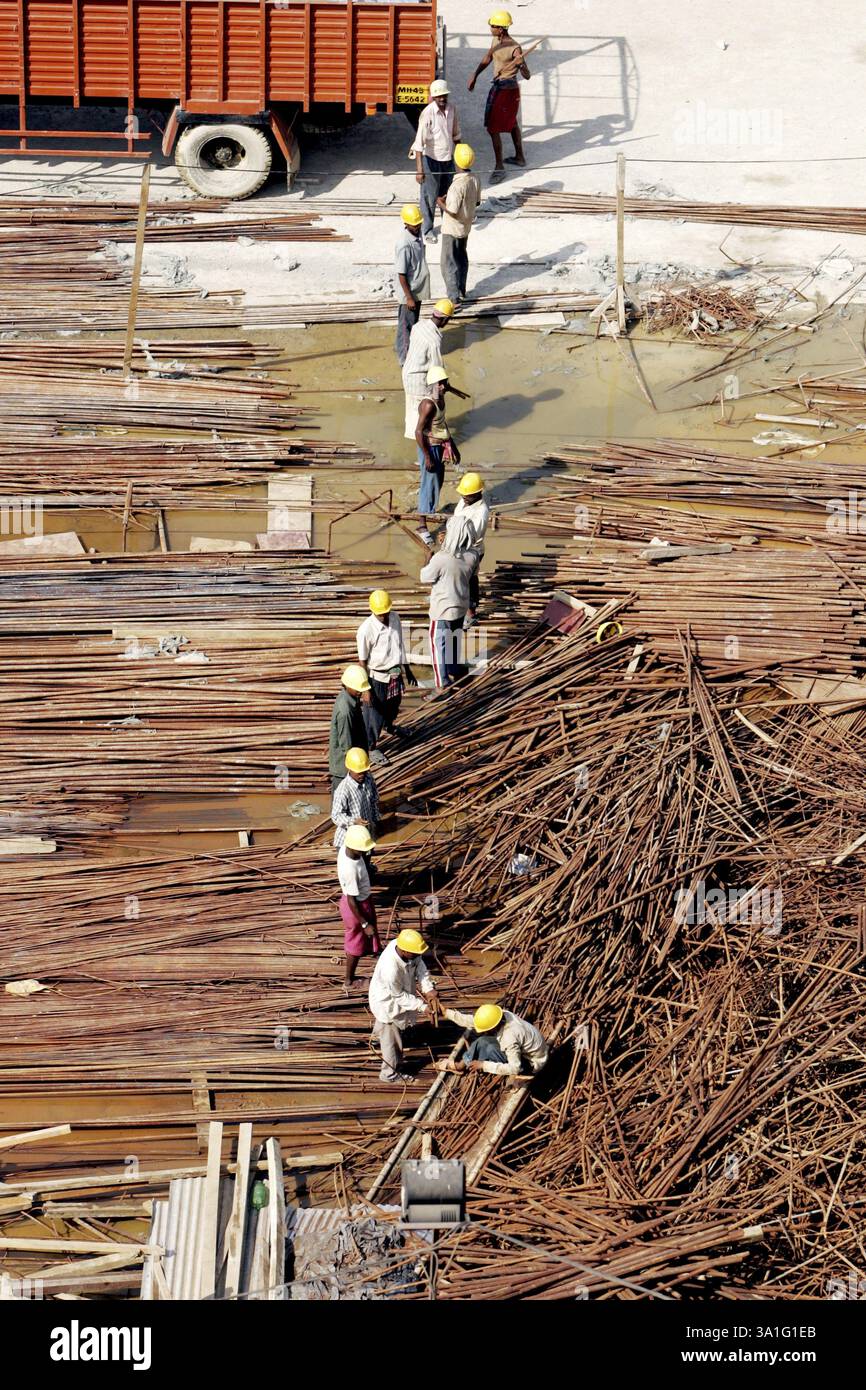 Workers straightening the iron rods needed to lay the foundation of ...