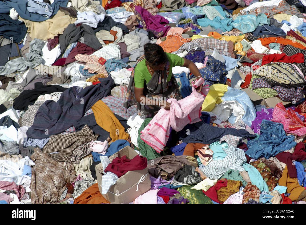 A woman selecting clothes from the stacks of clothes that arrived ...