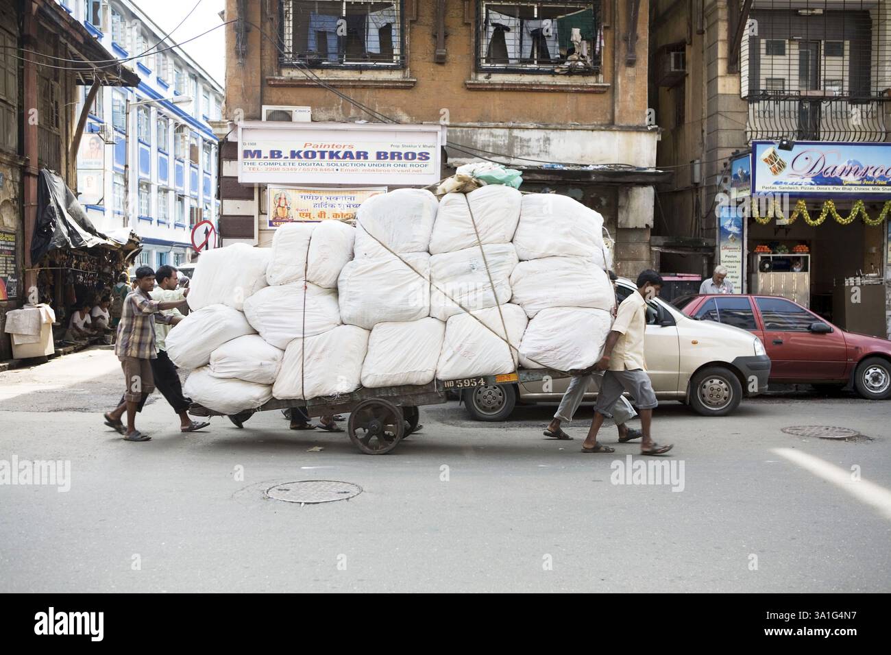A hand cart loaded with cotton bales pulled by two people, Bombay now ...