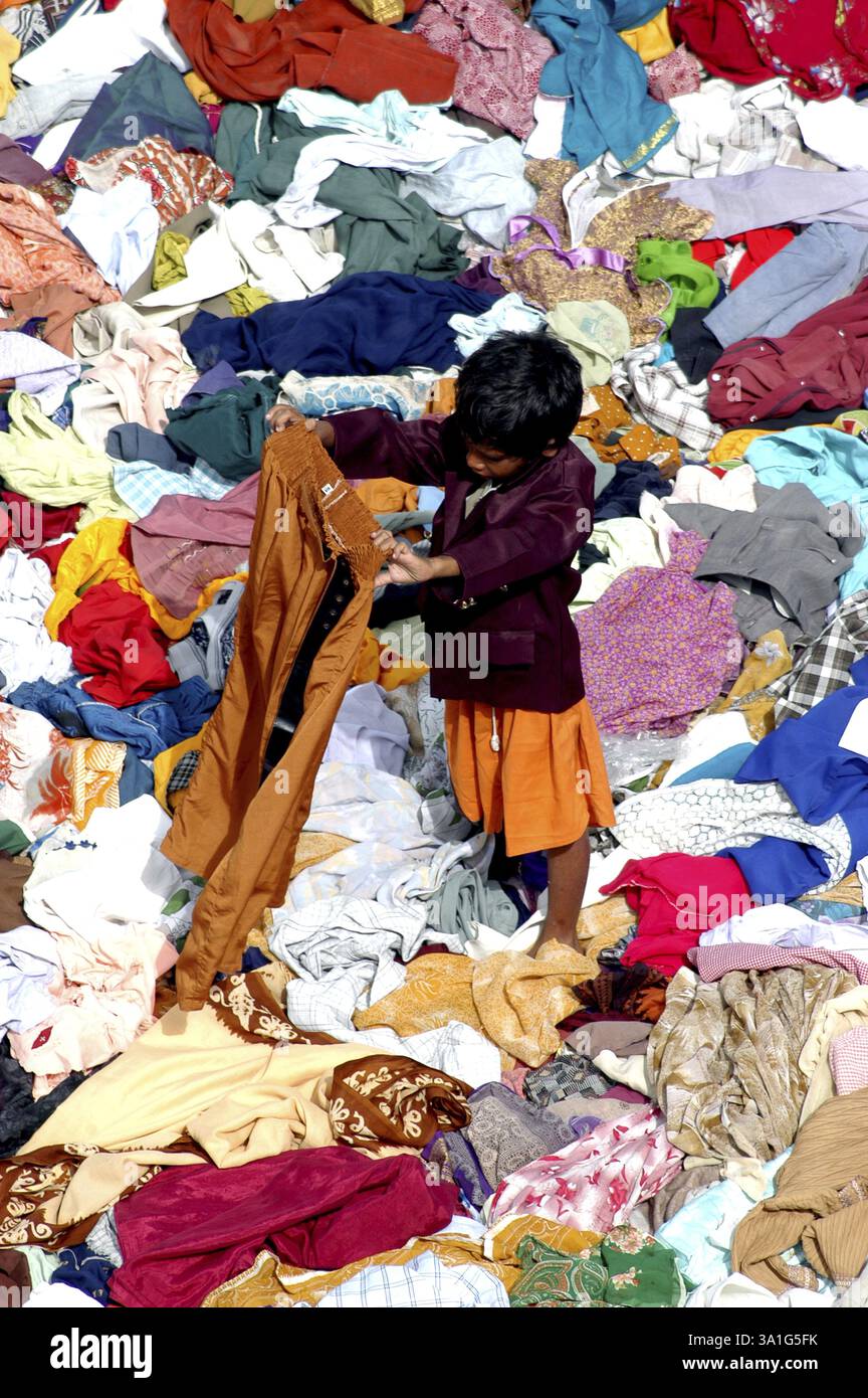 A girl selecting clothes from the stacks of clothes that arrived ...
