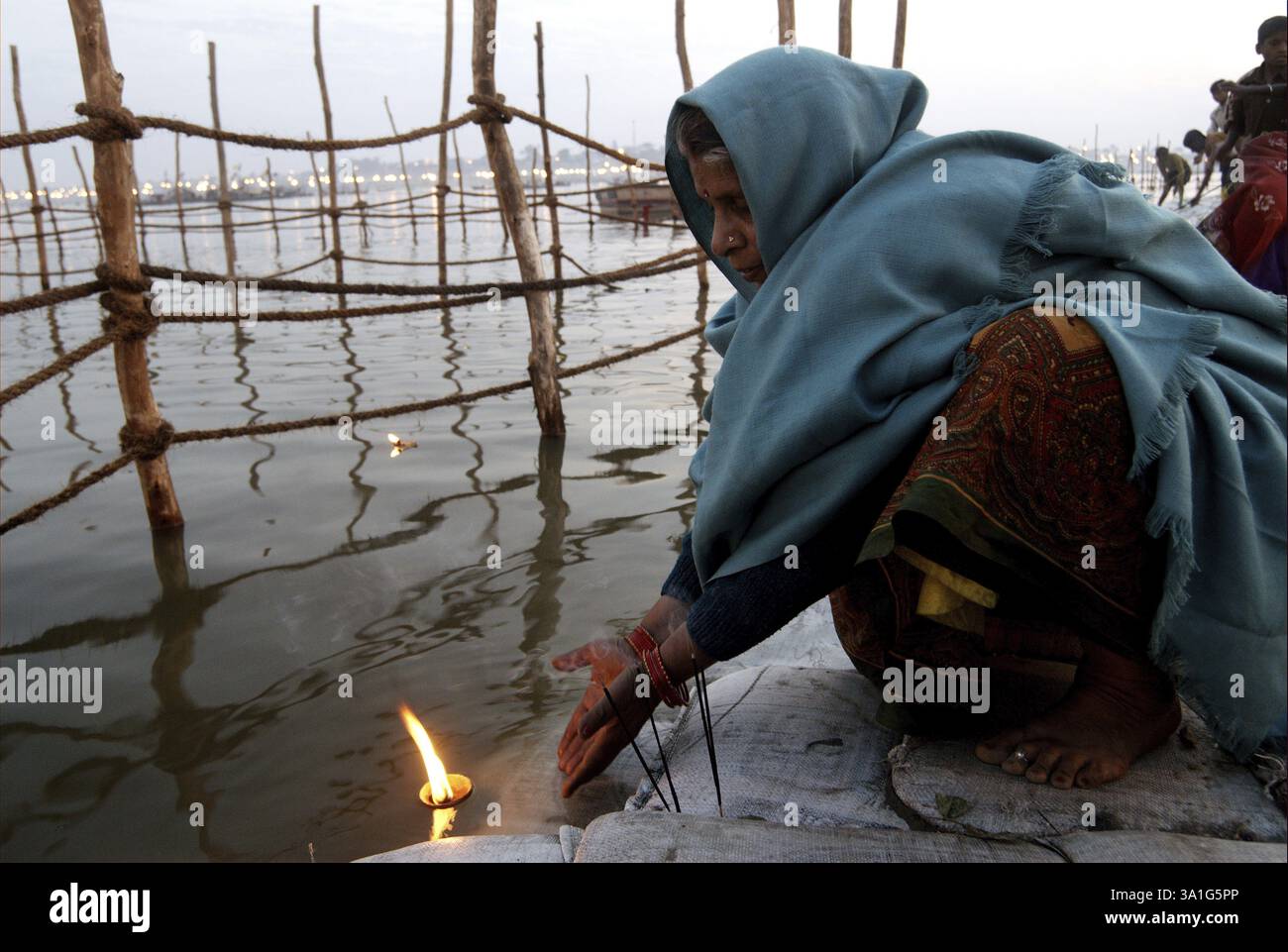 A devotee perform Ganga Aarti at the confluence of the Ganges, Yamuna ...