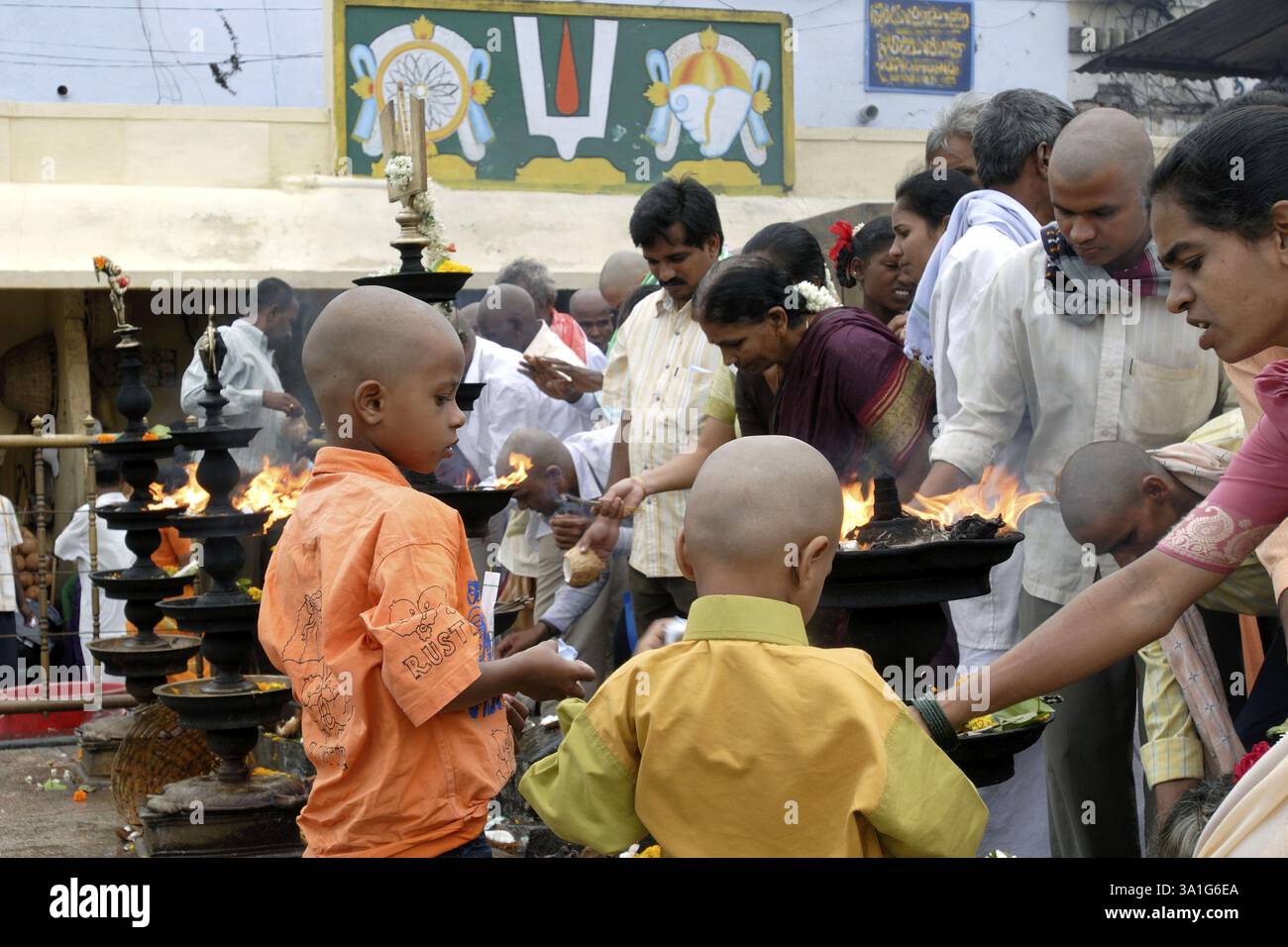 Devotees worshipping and offering coconut, camphor and flowers to Lord ...