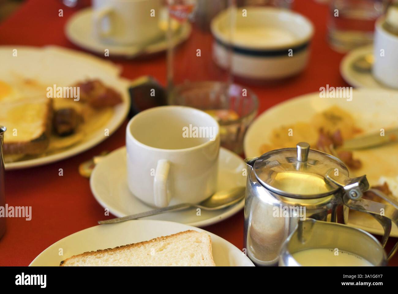 English breakfast laid on red table with tea cups kettles, Goa, India ...