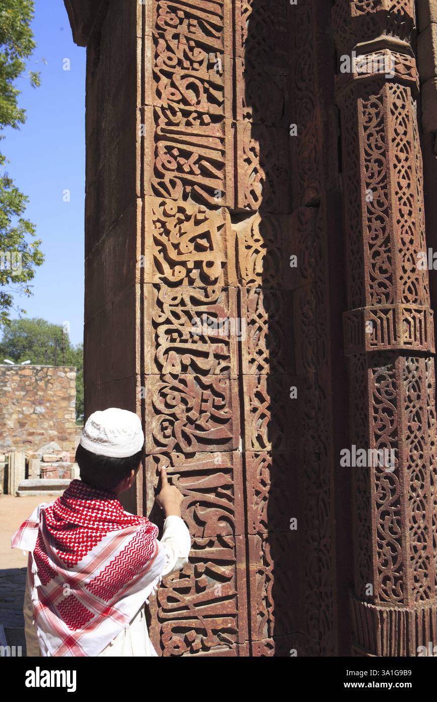 Muslim boy watching Islamic Ornamentation of Quran inscription carved ...