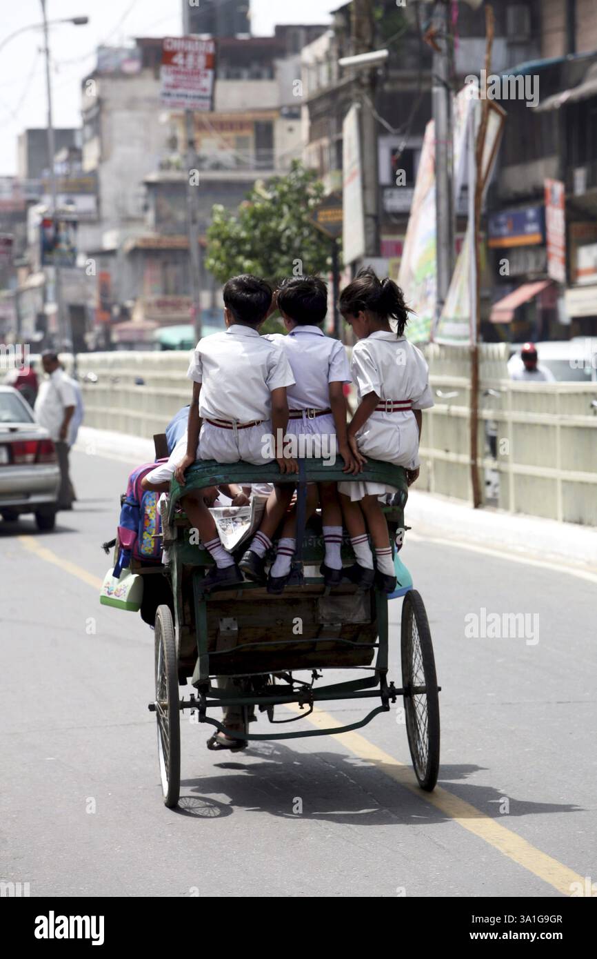 A tricycle rickshaw carrying school children home after the school got ...