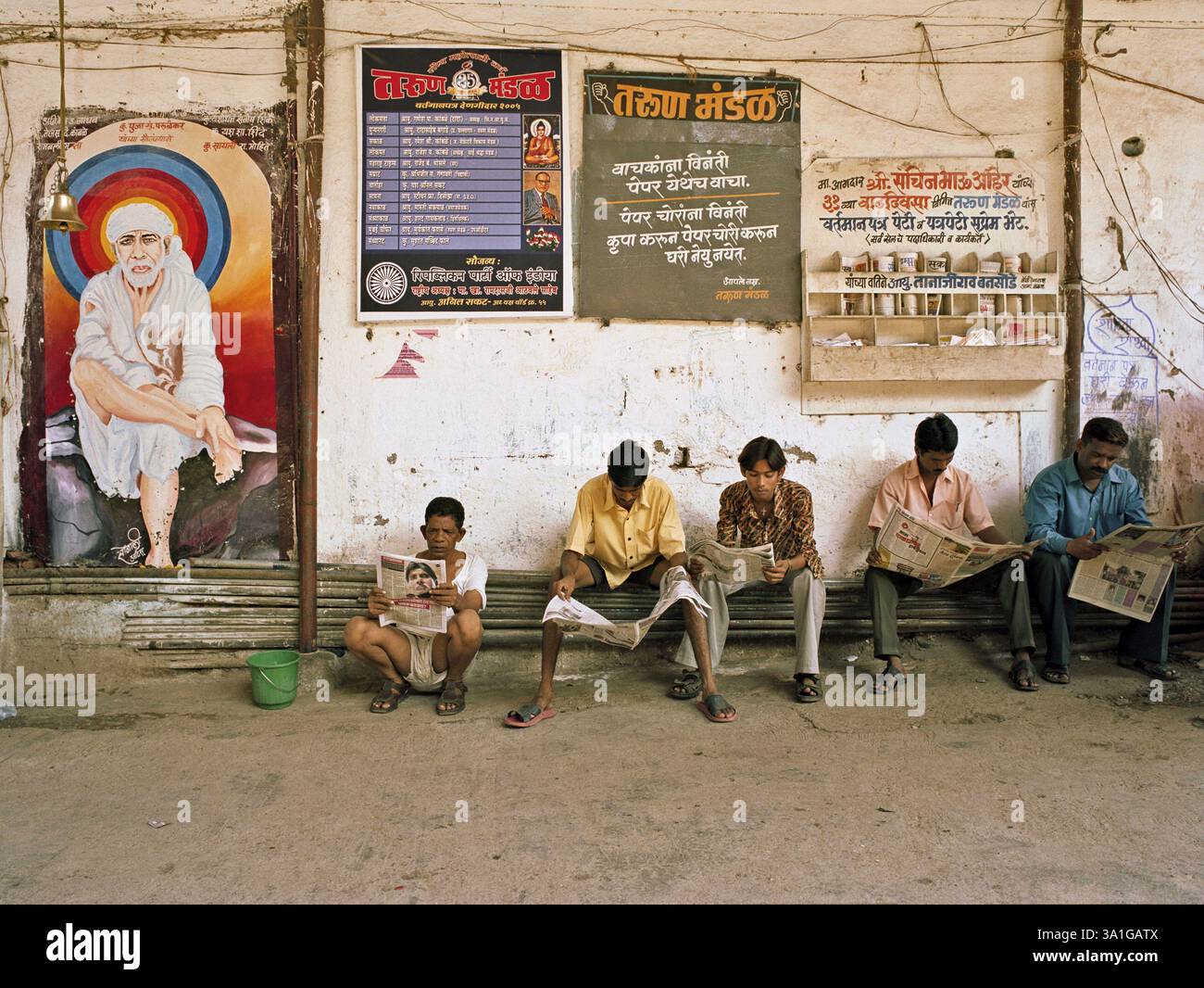 People reading daily newspapers seating on water pipes, Bombay now ...