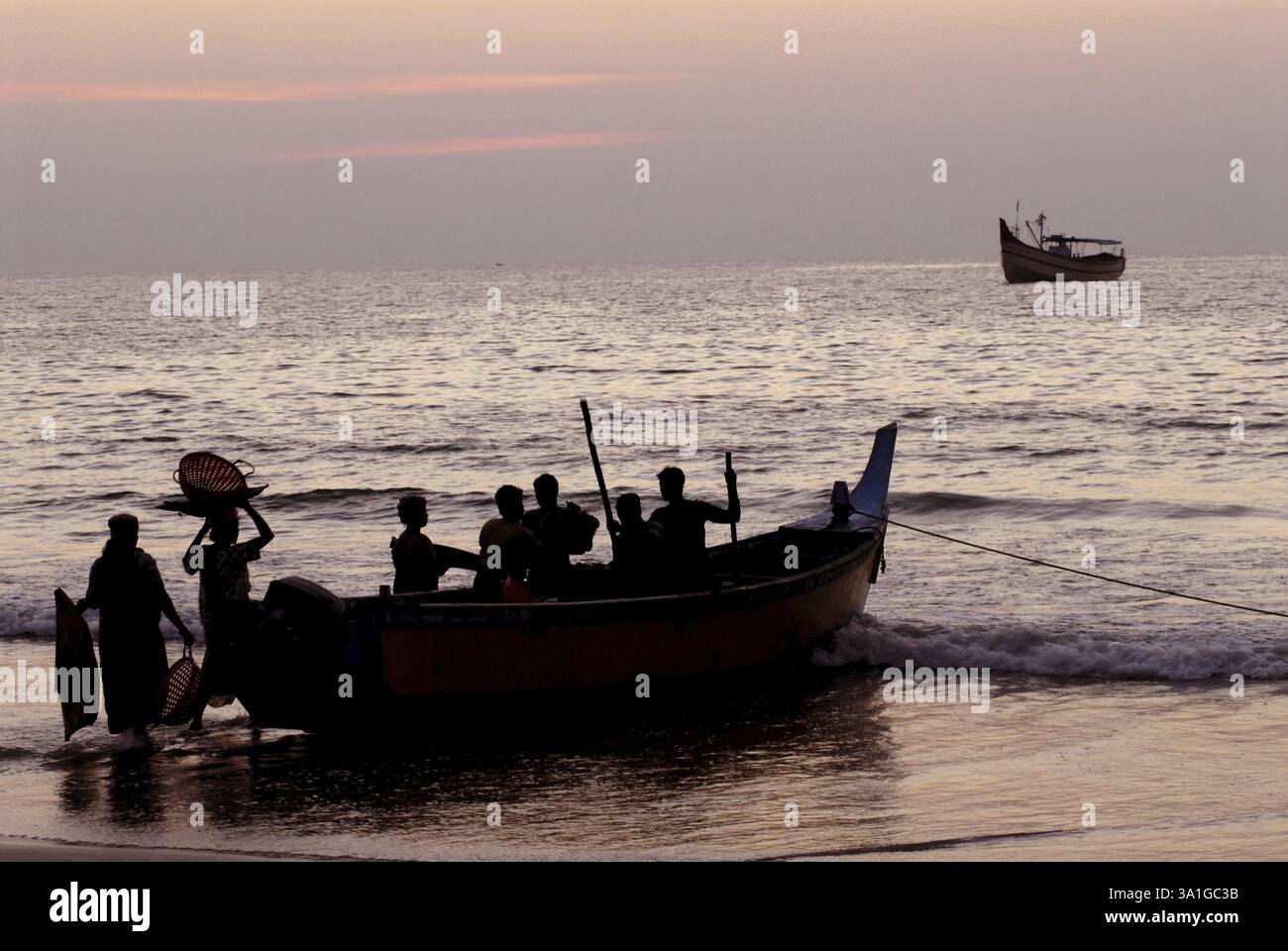 Colorful sunset with country fishing boat and fishermen unloading fish ...