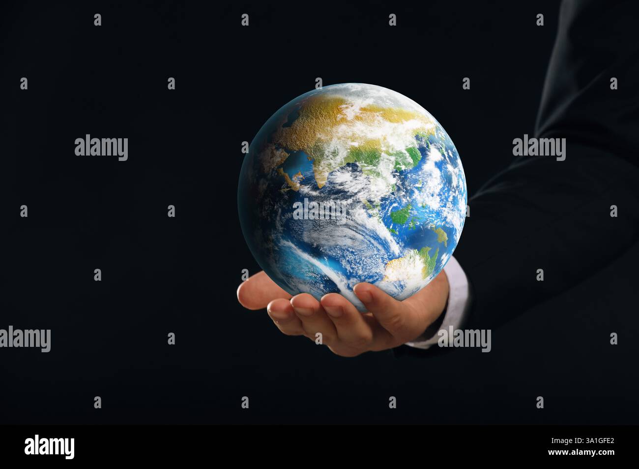 Planet in our hands. Man holding Earth model on black background ...