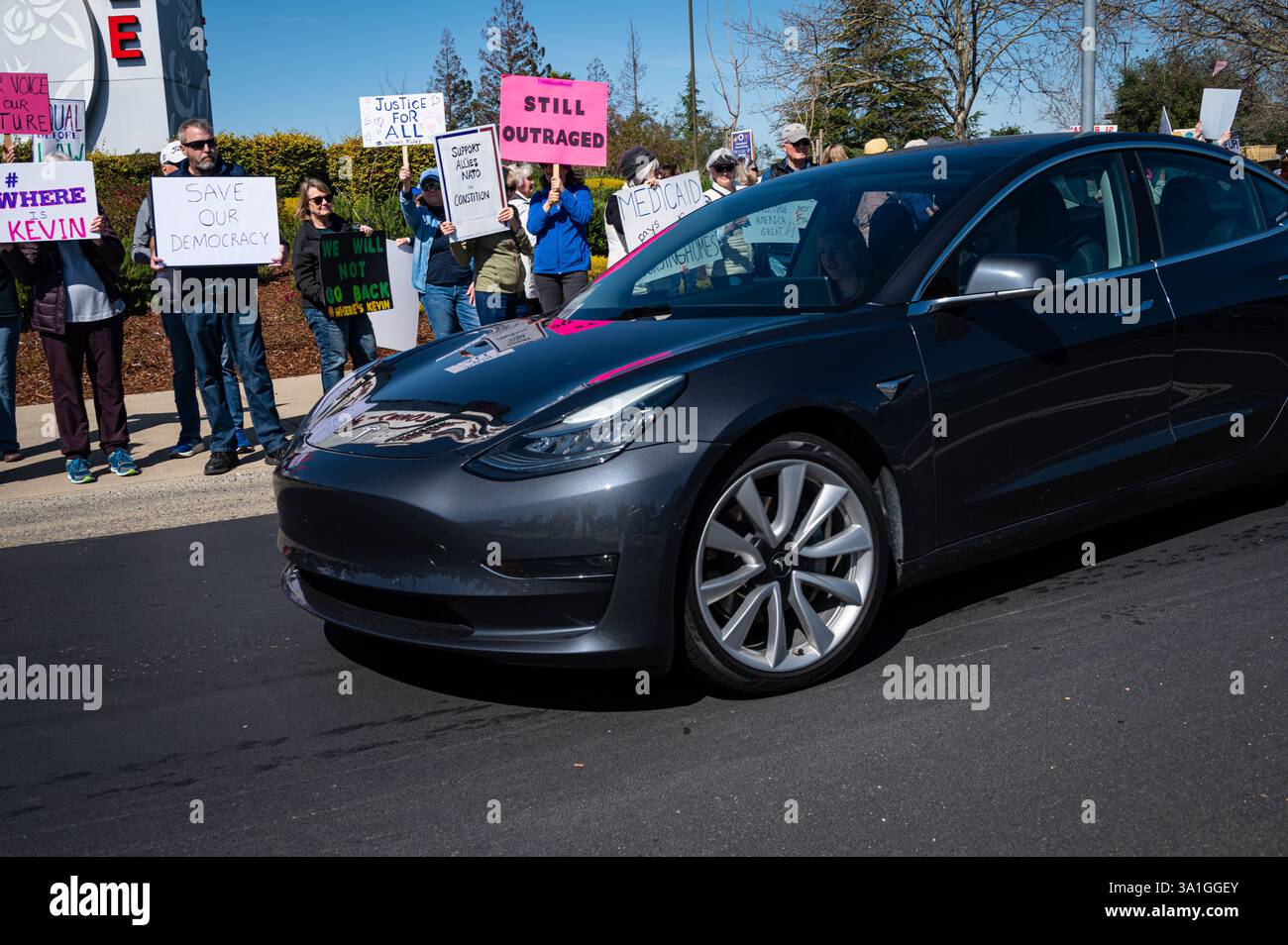 Protesters wave signs about being outraged and saving democracy at a ...