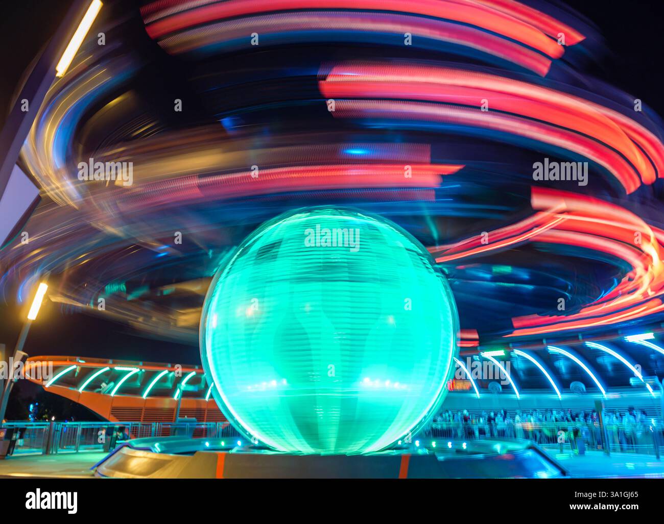 Colorful spinning attraction at nighttime amusement park featuring ...