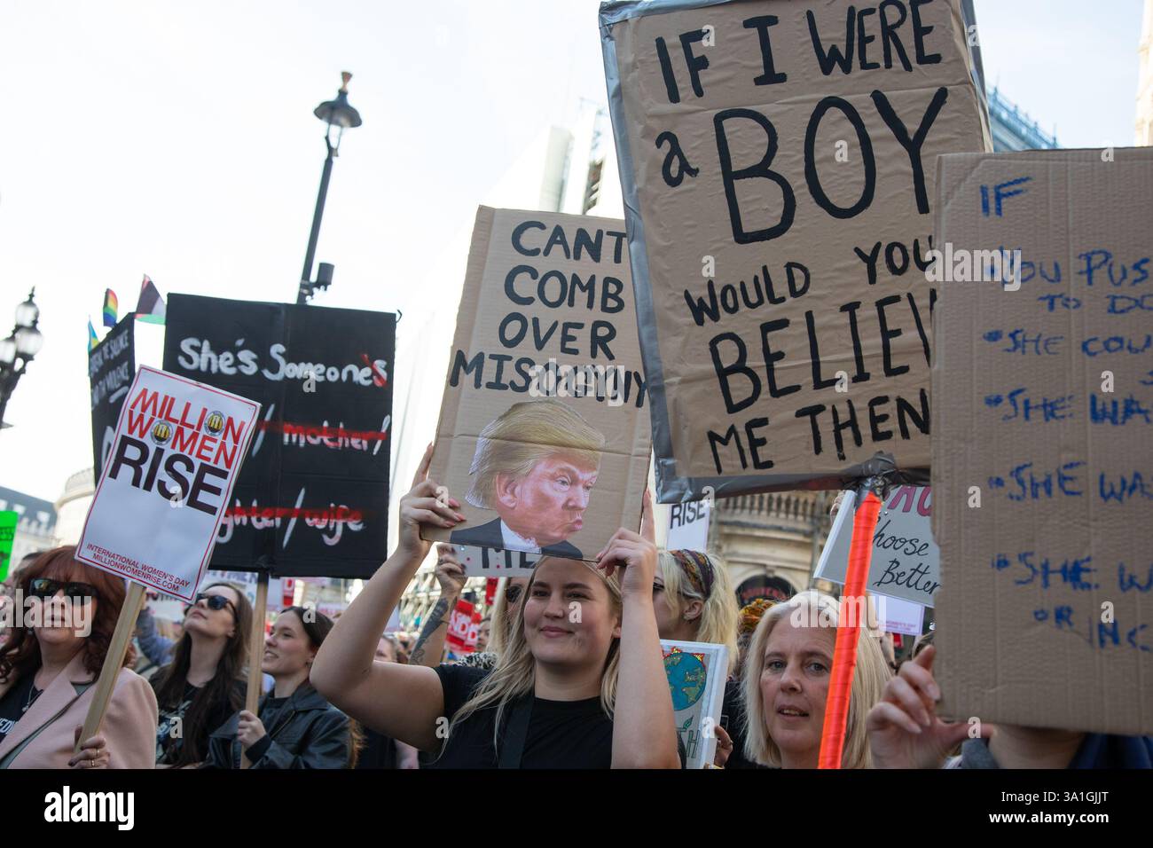London, England, UK. 8th Mar 2025. Women hold up signs during the ...