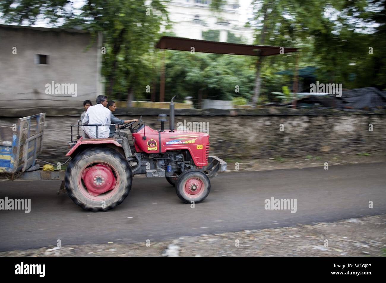 Red color tractor passing on Village Dilwara, Udaipur, Rajasthan, india ...