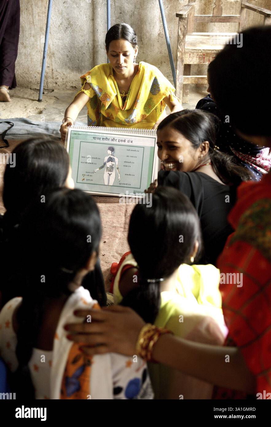 Woman showing health chart to villagers, Ngo Mahila Vikas Samity ...
