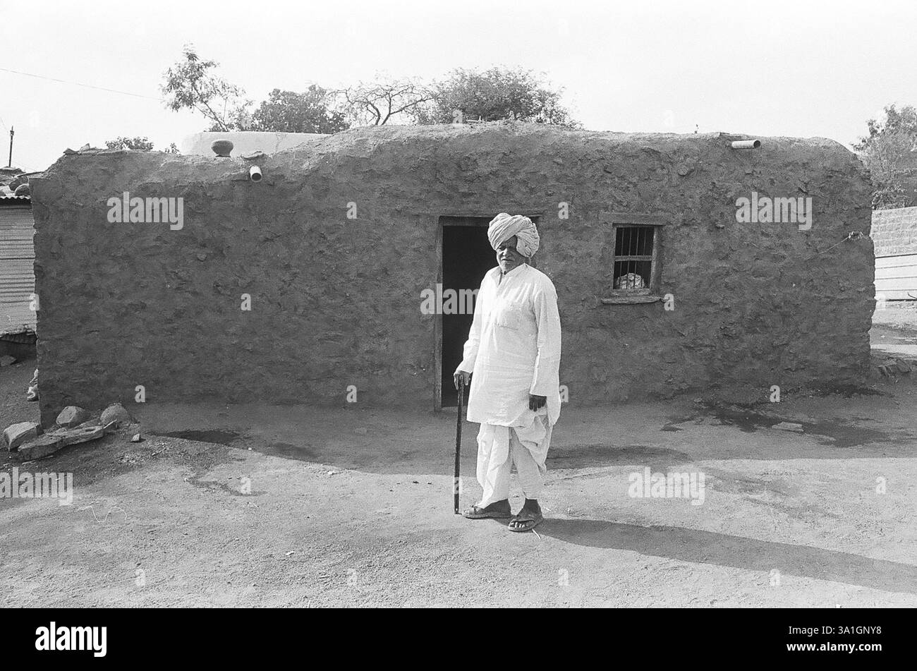 Rural man standing outside of his house, Munagoli village, Bijapur ...