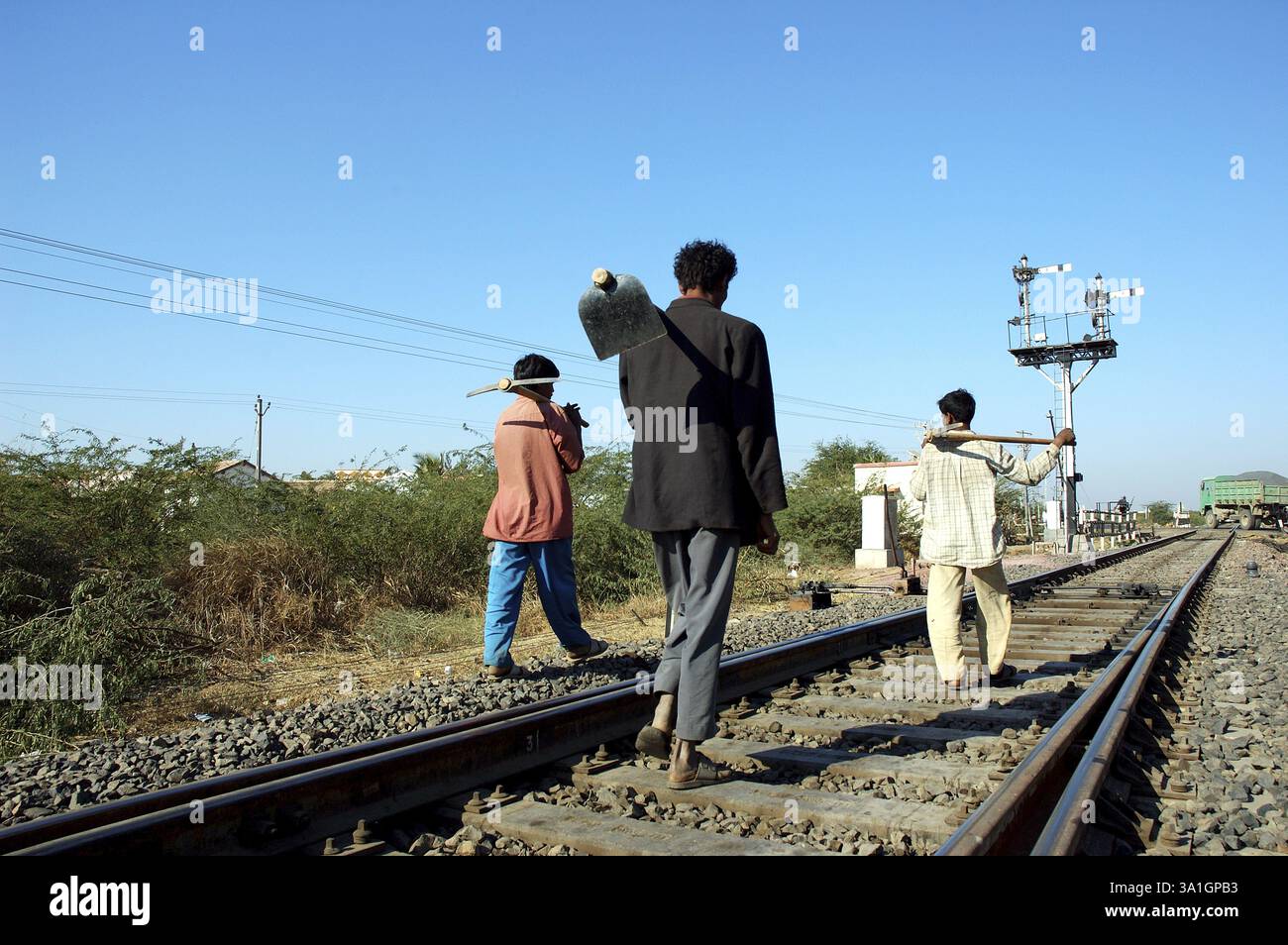 Workers walking in Meterguage railway tracks and signal, Gujarat, India ...