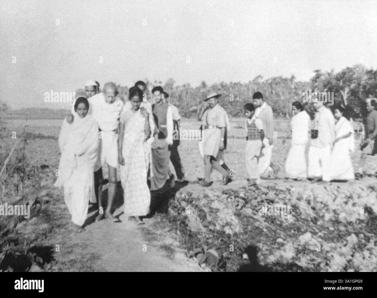 Mahatma Gandhi, supported by Amtus Salam, walking with others through ...