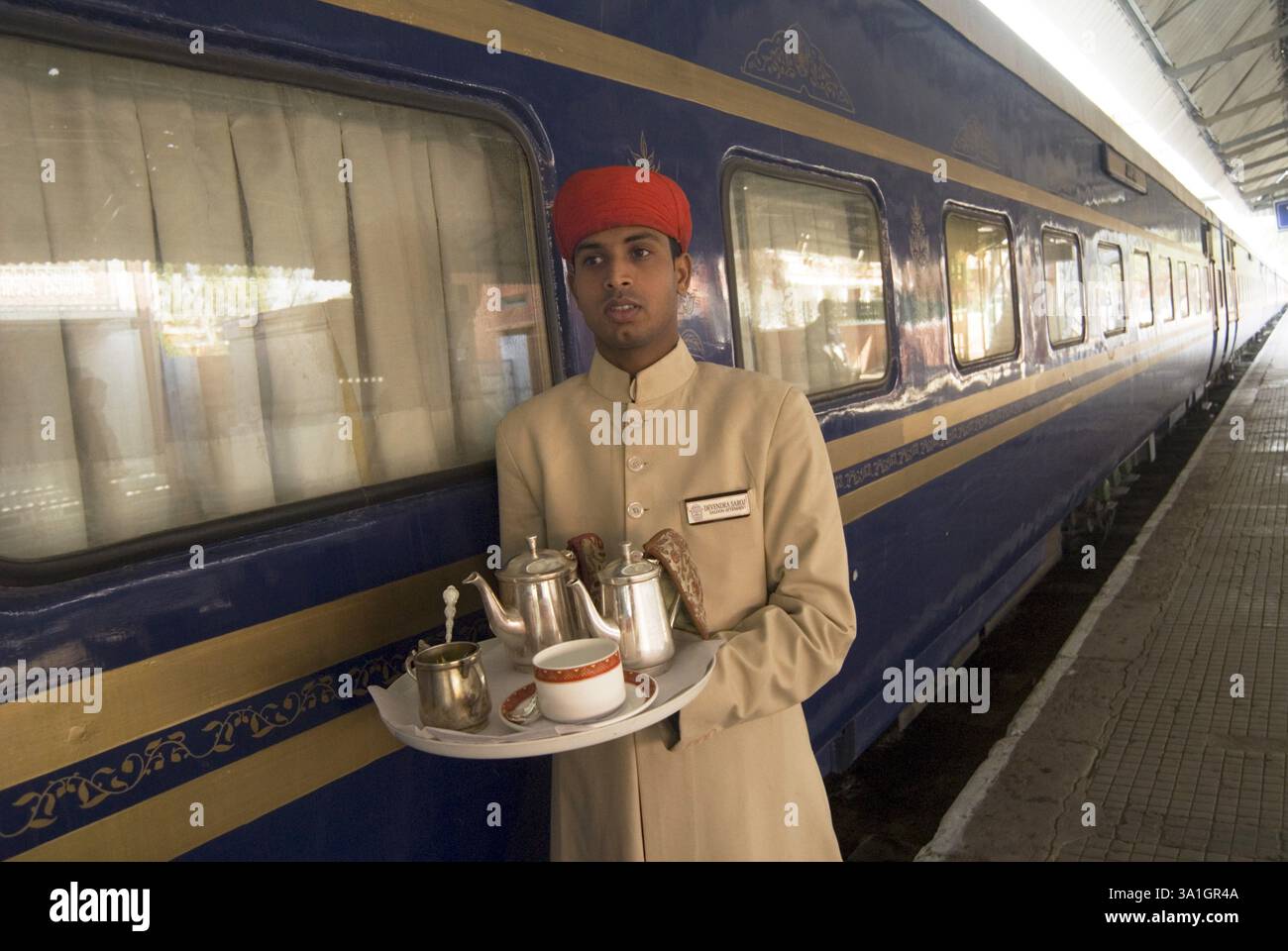 Rajasthani attendant holding tray of beverage standing outside of ...