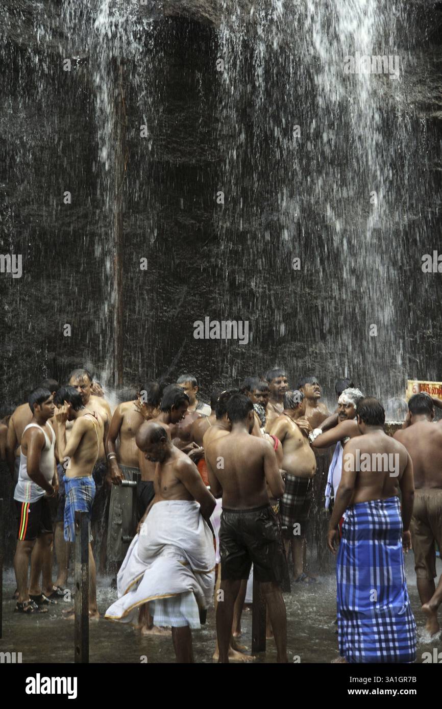 People getting wet under the waterfall, Kurtallum, Tamil Nadu, India ...