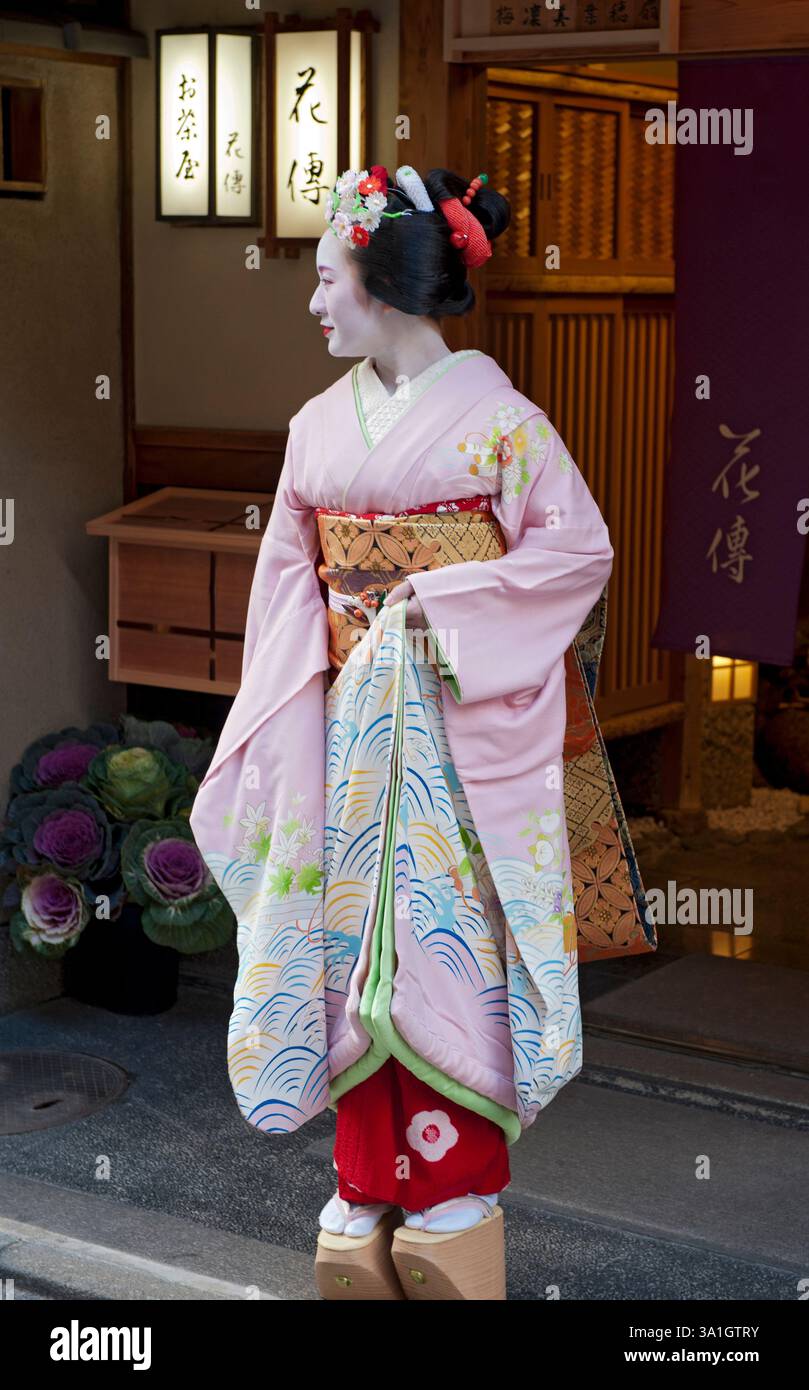 A Japanese maiko, or apprentice geisha or geiko, at an okiya teahouse in the hanamachi district ...