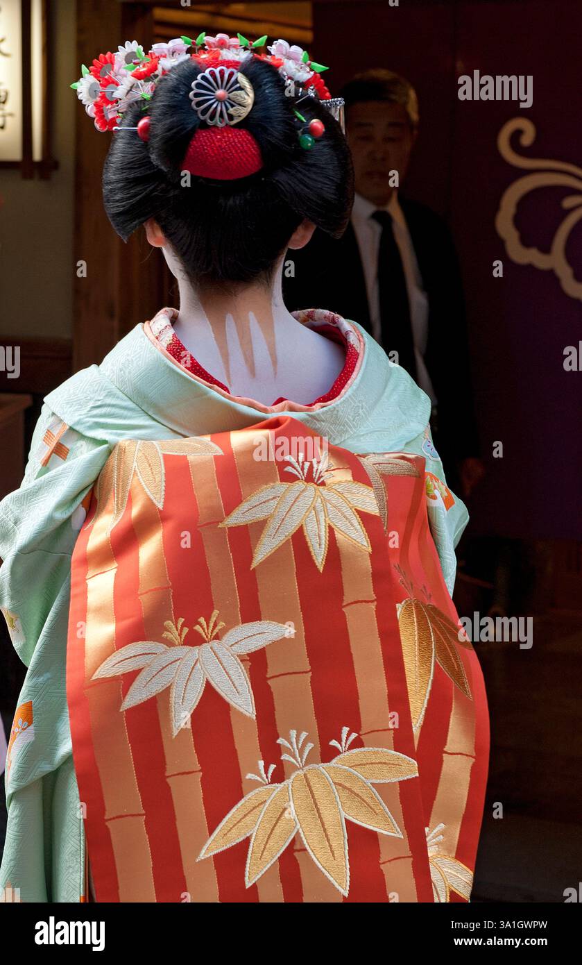 A Japanese maiko, or apprentice geisha or geiko, at an okiya teahouse in the hanamachi district ...